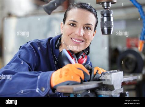 Female Apprentice Using Drill In Factory Stock Photo Alamy