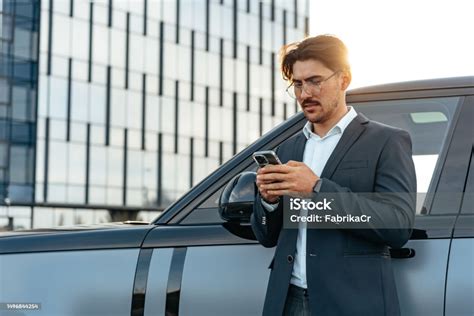 고급 자동차 근처에 서서 스마트폰을 사용하는 젊은 사업가 25 29세에 대한 스톡 사진 및 기타 이미지 25 29세 거리 경영자 Istock