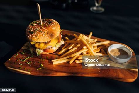 큰 샌드위치 육즙이 많은 쇠고기 버거 감자 튀김 토마토 나무 보드에 녹은 치즈를 곁들인 햄버거 0명에 대한 스톡 사진 및 기타 이미지 Istock