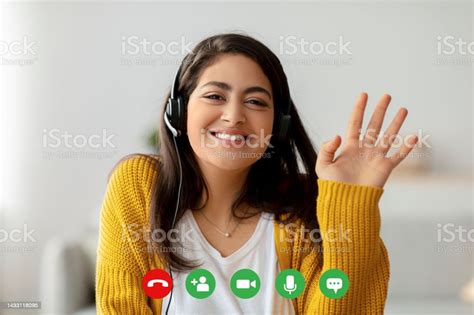헤드폰을 착용하고 웹캠에 손을 흔들고 화상 통화를하고 컴퓨터 화면보기를하는 행복한 아랍 여성의 헤드 샷 여자에 대한 스톡 사진 및 기타 이미지 Istock
