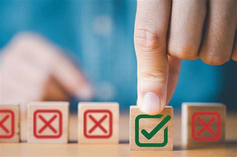 사업가는 비즈니스 프로젝트 제안 개념을 승인하고 거부하기 위해 나무 큐브 블록에 화면을 인쇄하는 적십자 마크 사이에 녹색 올바른