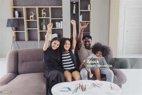 젊은 아시아계 미국인 가족 부모와 어린 딸이 집에서 함께 그림을 그립니다 아시아계 미국인 가족과 아빠가 거실에서 아이와 함께 그림을 그리고 연필을 사용하고 재미 있고