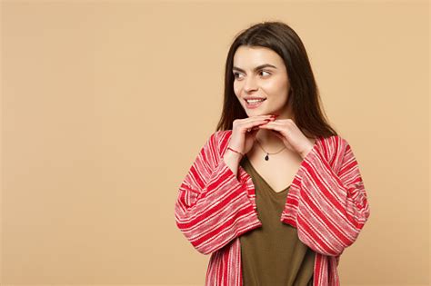 캐 쥬얼 한 옷을 입고 웃는 젊은 여자의 초상화 스튜디오에서 파스텔 베이 지 배경에 고립 된 턱에 손을 올려 놓습니다 사람들은 진심으로 감정 라이프 스타일 개념입니다 복사