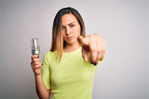 카메라와 당신에 게 손가락으로 가리키는 고립 된 흰색 배경 위에 전구를 들고 젊은 아름 다운 금발여자 손 기호 앞에서 긍정적이 고 자신감 제스처 가리키기에 대한 스톡 사진