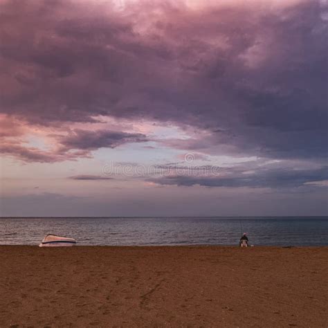 Alone Old Man Fishing In The Aegean Sea At Sunset In Summer Season