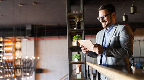 태블릿을 사용하여 현대 사무실에서 양복을 입은 행복한 젊은 사업가 사진 Unsplash의 양복 이미지