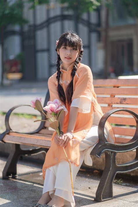 격식있는 옷차림 공원 벤치 긴 머리 꽃 꽃을 들고 도시 배경 도시의 드레스 맑은 날 머리띠 모델 문화 유산 문화 의류 문화 패션 민족 드레스