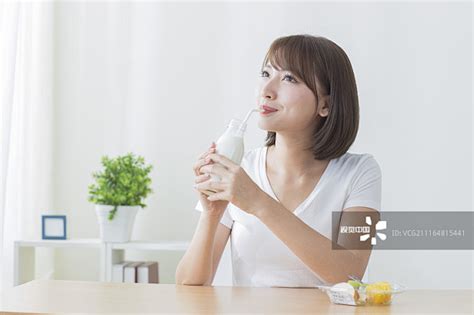 年轻女人早晨起床喝牛奶图片素材
