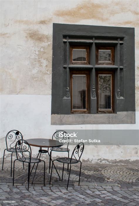 검은 색 원형 테이블과 돌 포장에 4 개의 금속 의자가있는 오래된 어두운 골동품 창 식사 식품 및 음료에 대한 스톡 사진 및 기타 이미지 식사 식품 및 음료 원형탁자