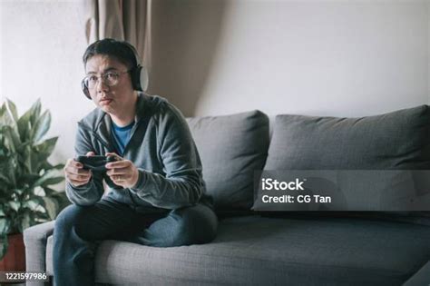 그의 헤드셋과 거실에서 집에서 비디오 게임을 하는 아시아 중국 중반 성인 남자 Brand Name Video Game에 대한 스톡 사진 및 기타 이미지 Brand