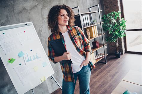 클립 보드를 들고 현대적인 사무실에서 곱슬 머리를 가진 자신감 넘치는 젊은 사업가가 집중하고 일할 준비가되어 있습니다 25 29세에 대한 스톡 사진 및 기타 이미지 Istock