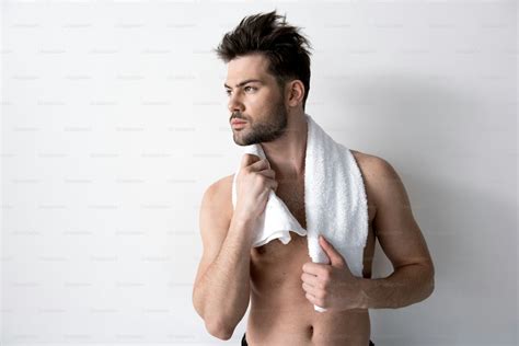 헝클어진 머리를 한 뻣뻣한 남자가 서서 목에 흰 수건을 들고 있습니다 그는 진지하게 옆을 바라보고 있습니다 왼쪽의 복사 공간 사진 Unsplash의 복사 공간 이미지