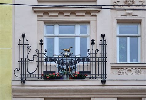 Изысканный фасад с кованым балконом и скульптурой птицы