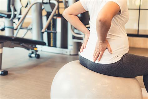 요가룸의 피트니스 센터에서 활동적인 임산부 운동을 합니다 임신 한 배에 아기를 들고 젊은 기대 어머니 출산 전 관리 및 여성 임신 개념 운동에 대한 스톡 사진 및 기타