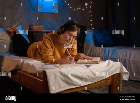 Female College Babe Reading Thick Book And Taking Notes In Textbook On Bed Stock Photo Alamy