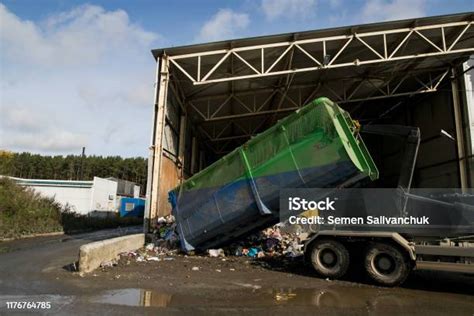 폐기물 처리 공장에 후속 운송을 위한 특수 기계에 폐기물로 컨테이너를 적재 폐기물 처리 공장 폐기물의 선별 및 처리를 위한 비즈니스 공장 산업 건물에 대한 스톡 사진 및