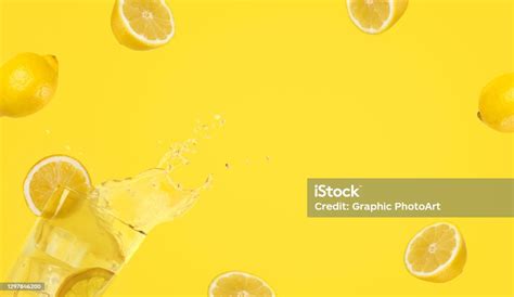 날아다니는 레몬과 신선한 레모네이드 한 잔에 얼음이 떨어지고 물보라를 일으킵니다 노란색 배경에 공간을 복사합니다 여름 시간