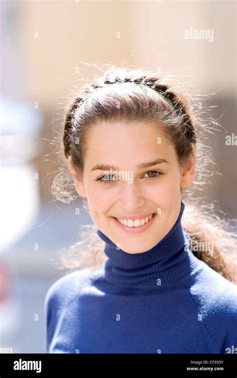 Female With Dark Blonde Hair Tied Up With Head Band Wearing Blue Polo