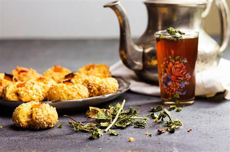 오리엔탈 알제리 의 달콤한 쿠키를 곁들인 전통 모로코 차 맥하왁 아랍어로 명명 찻잔과 냄비와 민트 잎 0명에 대한 스톡 사진 및