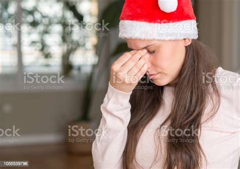 아름 다운 젊은 여 자가 집에서 산타 클로스 모자를 쓰고 문 지르고 코와 눈 피로 두통 느낌 피곤 스트레스와 좌절 개념입니다 갈색 머리에 대한 스톡 사진 및 기타 이미지
