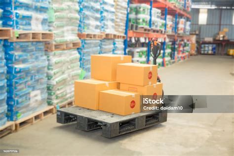 창고 또는 창고 재고 제품 재고에 핸드 팔레트 트럭이화물 상자 저장 물류 배경에 대한 제품을 저장하기위한 대형 산업 공장의 선반에있는 소매 상자 0명에 대한 스톡 사진 및