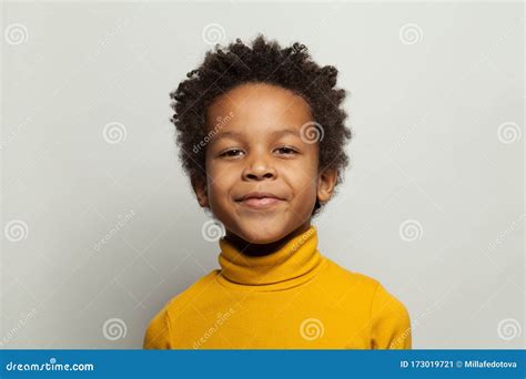 Красивый черный мальчик ребенка улыбаясь и глядя на камеру на белом фоне Стоковое Изображение