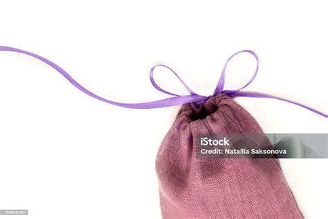 리본으로 묶인 보라색 린넨 파우치 작은 물건을 보관하기위한 가방 말린 허브 향기로운 가방 인테리어 세부 사항 선물 흰색 배경에 고립되어 있습니다 공간을 복사합니다