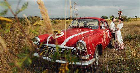 세련된 신부와 행복한 신랑은 자연을 배경으로 빨간 복고풍 자동차 근처 사진 Unsplash의 자동차 이미지