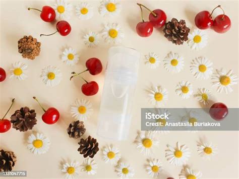 아이보리 배경에 친밀한 윤활유 젤 카모 마일 체리 베리와 전나무 콘의 투명 병의 모형 브랜딩 및 라벨용 병 플라워 플랫 레이