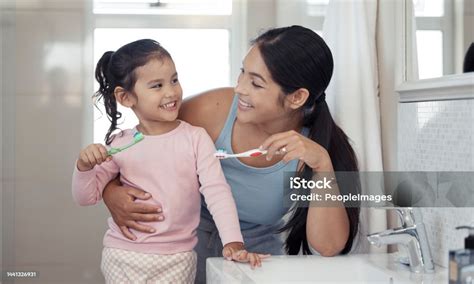 구강 또는 치아 건강을 위해 욕실에서 함께 칫솔로 양치질하는 법을 배우는 소녀와 함께하는 어머니 행복하고 사랑하며 돌보는 엄마는 아이 또는 아이에게 치과에 대해 가르치고