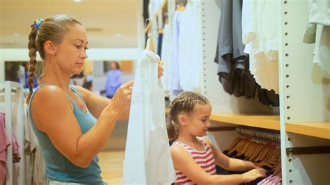 Cute Shopaholic Mom And Daughter Choose Looking For Clothes In Clothing
