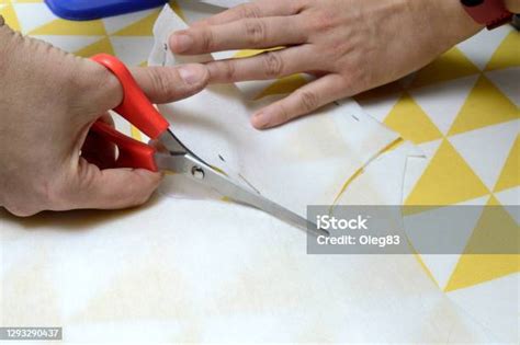 Tangan Wanita Memotong Kain Dengan Gunting Sesuai Dengan Pola Di Atas