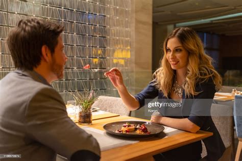 Couple Showing Love While Having Romantic Dinner In Restaurant High Res
