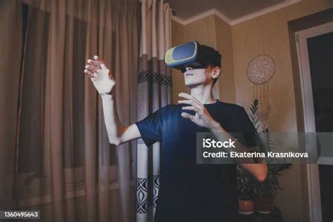 Vr 헬멧을 쓰고 있는 청년이 집 내부의 가상 현실에서 물체와 상호 작용합니다 20 24세에 대한 스톡 사진 및 기타 이미지 20 24세 3차원 형태 가상현실