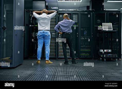 Meanwhile In The Server Room Rearview Shot Of Two It Technicians