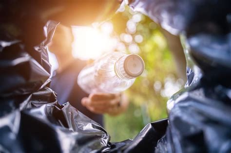 Premium Photo Man Throws Garbage Into A Garbage Can On The Street With A Worm View From The