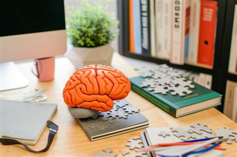 A 3d Printed Brain Model On A Desk With Books And A Computer Premium Ai Generated Image
