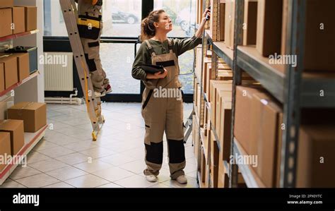 Woman Manager Working On Stock Inventory With Tablet Scanner Verifying Barcodes Of Products In