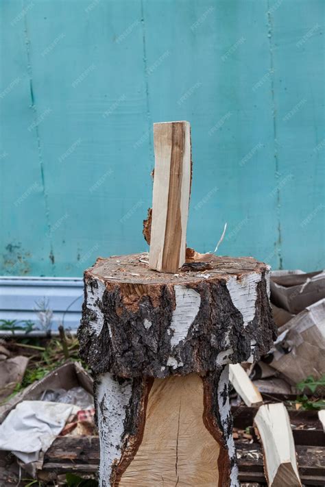 Premium Photo A Log Split In Half With An Ax On A Deck With Male Hands In Cloth Gloves And A