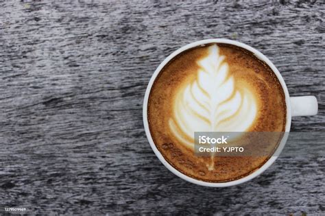 천연 목재 질감 배경에 흰색 세라믹 컵에 아름다운 우유 거품이있는 뜨거운 커피 0명에 대한 스톡 사진 및 기타 이미지 0명