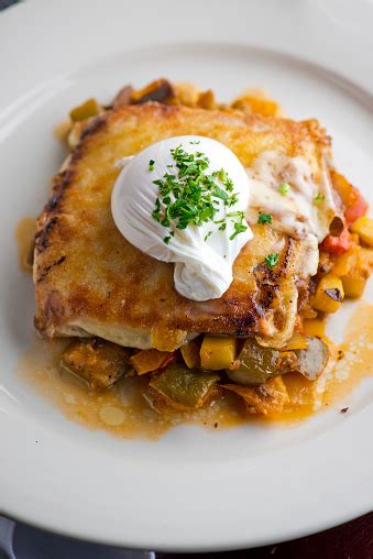 계란 베네딕트 아침 식사 또는 브런치 좋아하는 영국 머핀 데친 달걀 햄 록스 시금치 치즈 및 홀란데이즈 소스를 얹습니다 주철 프라이팬에 감자 해시가 제공됩니다 클래식 한