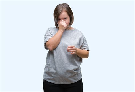 고립 된 배경 위에 다운 증후군을 가진 젊은 성인 여자는 피로와 두통을 느끼는 눈을 문질러 피곤 스트레스와 좌절 개념입니다 건강관리와 의술에 대한 스톡 사진 및 기타 이미지