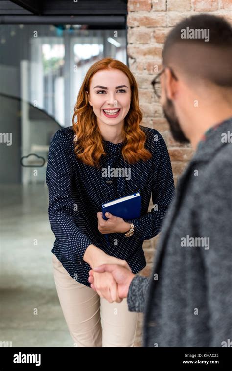 Smiling Redhead Woman Greeting The Recruiter At Job Interview Stock Photo Alamy