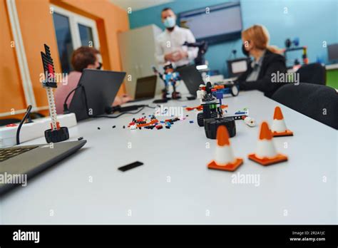 A Group Of Colleagues Working Together In A Robotics Laboratory Focusing On The Intricate