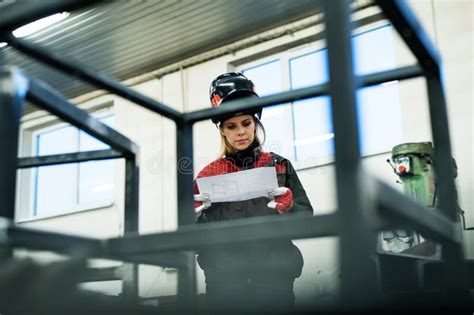 Beautiful Blonde Woman Works As A Welder In Workshop Reading