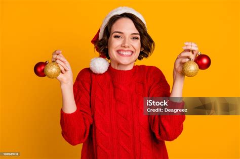 사진은 꽤 쾌활한 재미 여자의 사진 겨울 휴일 을 축하 크리스마스 공 선물 장식 상록 나무 착용 산타 캡 빨간 니트 스웨터 고립