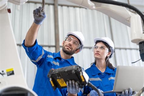 Premium Photo Male And Female Engineer Using Remote Controller Control Robot Arm Welding