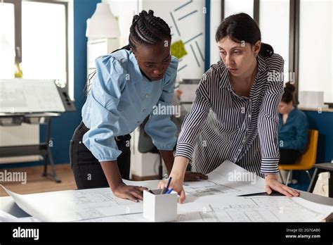 Architectural Team Of Multi Ethnic Women Plan Sketch Blueprint Layout For Design Project