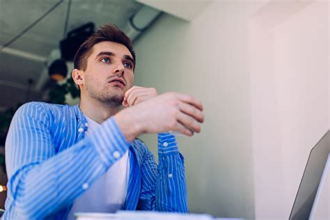 현대 노트북 기술과 테이블에 앉아 웹 디자인 프로젝트에 대한 아이디어를 숙고 하는 Pensive 남성 프리랜서 실내 원격 작업