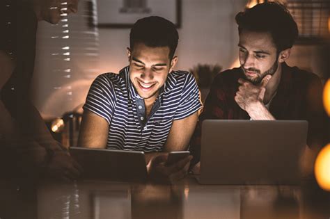 스마트폰 사용 하는 동안 소셜 네트워킹 사이트에 사진을 업로드 하는 친구 들을 웃 고 Brand Name Online Messaging Platform에 대한 스톡 사진 및